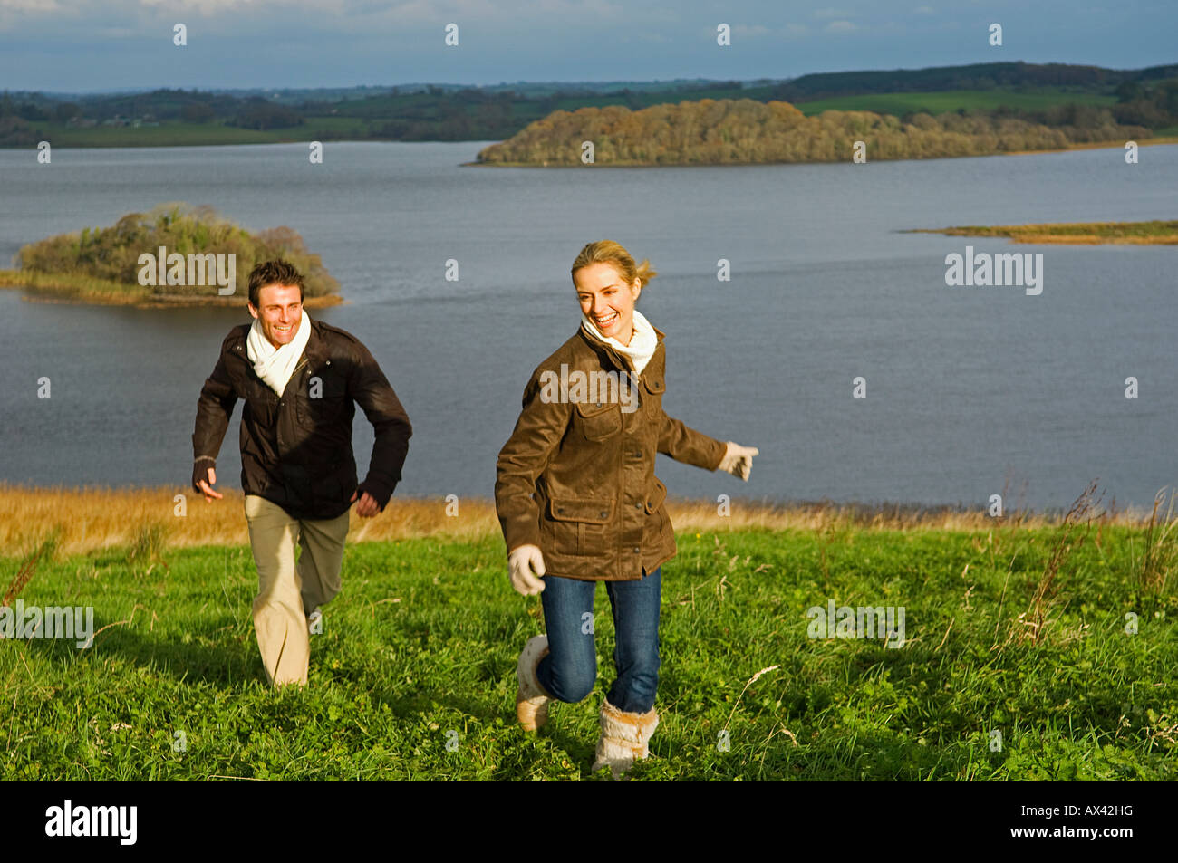 UK, Northern Ireland, Fermanagh. Couple chasing each other on a walk at ...
