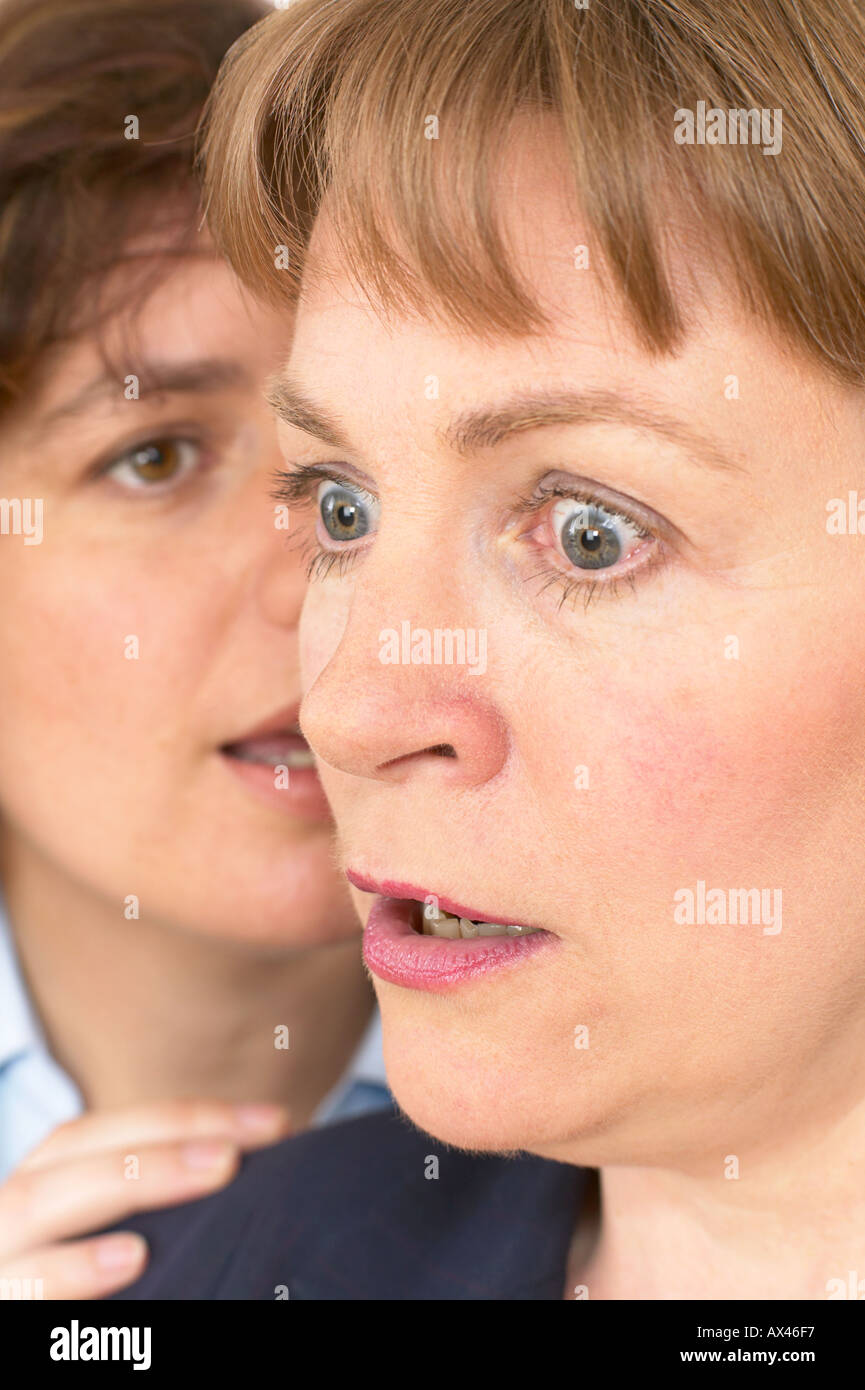 two women whisper a secret in close up of ear and mouth Stock Photo - Alamy