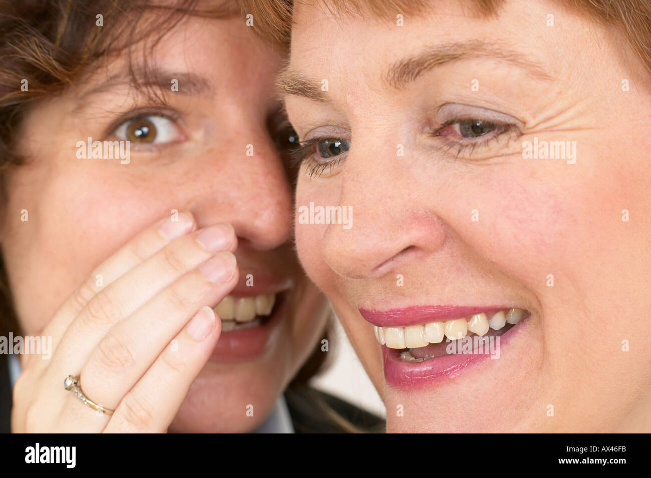 two women whisper a secret in close up of ear and mouth Stock Photo - Alamy