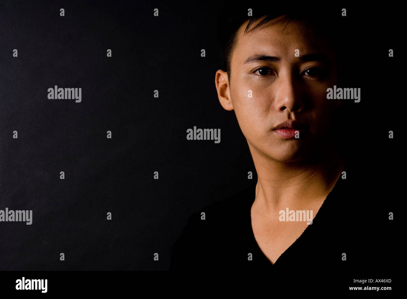 A young chinese male models a black shirt on a black background Stock ...