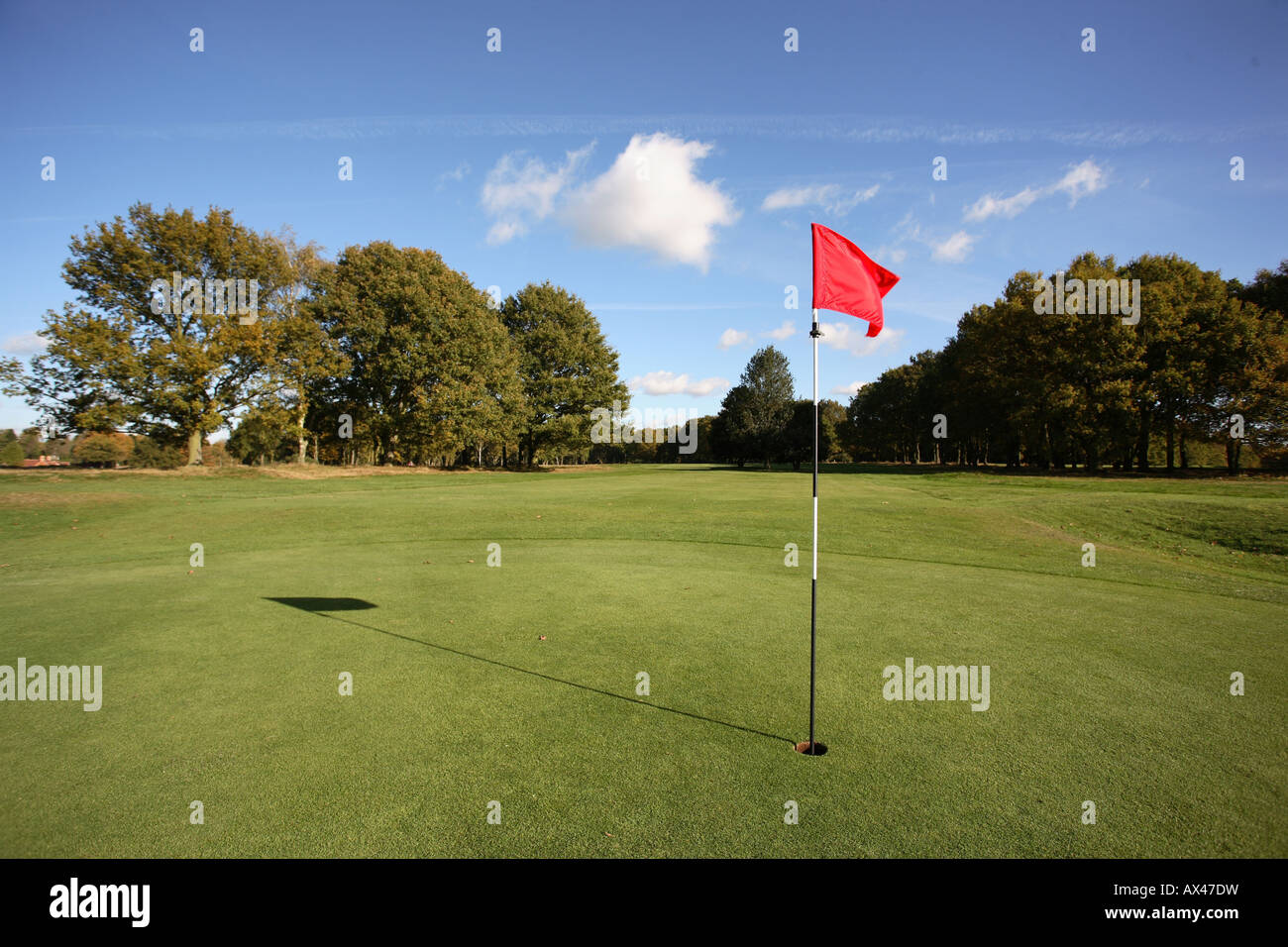 A golf course with red flag in foreground Stock Photo - Alamy