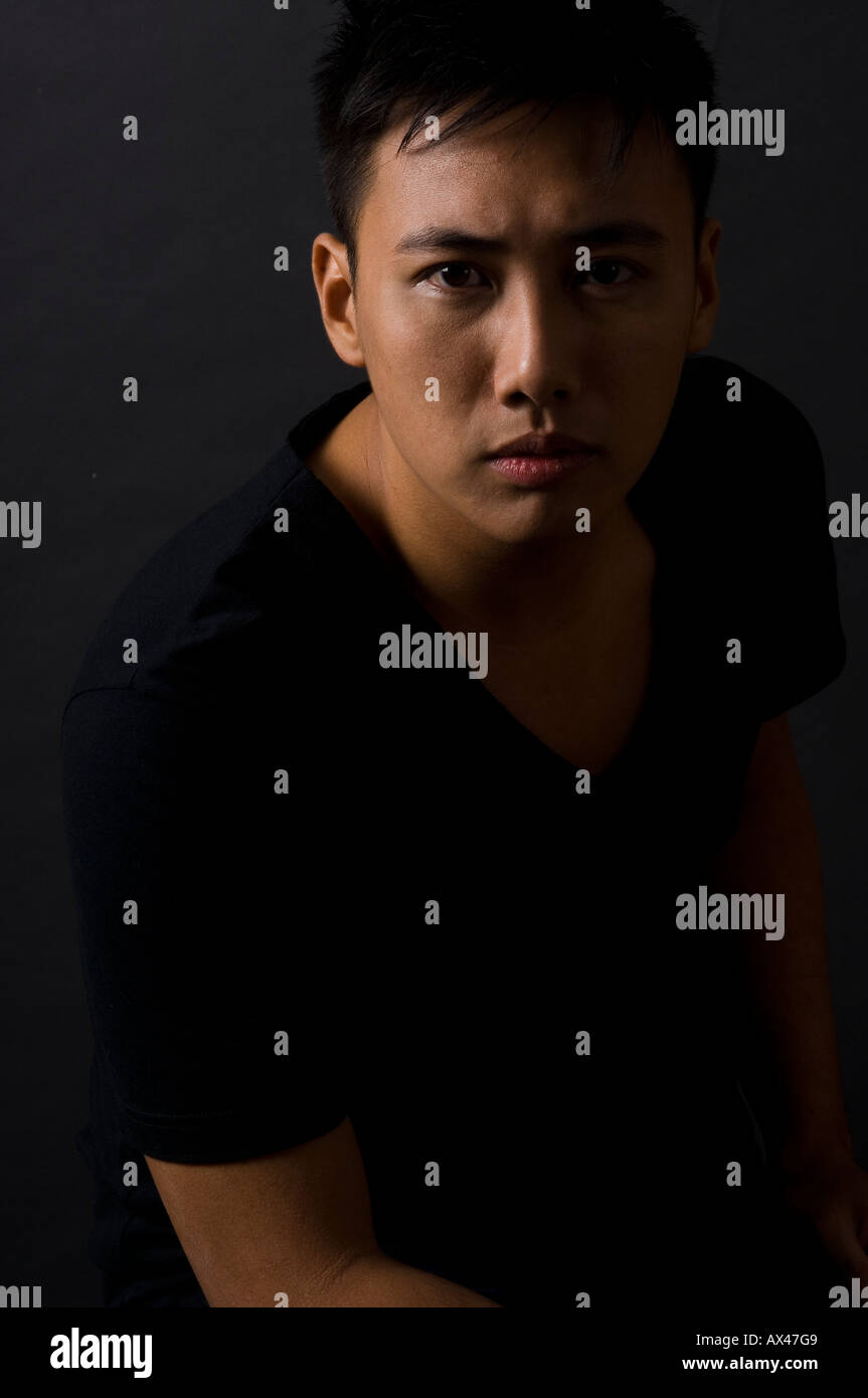 A moody and intense stare from a chinese male model in black Stock ...