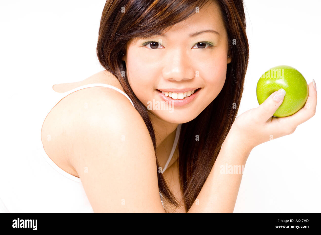 A healthy looking pretty chinese girl in white holding a green apple ...