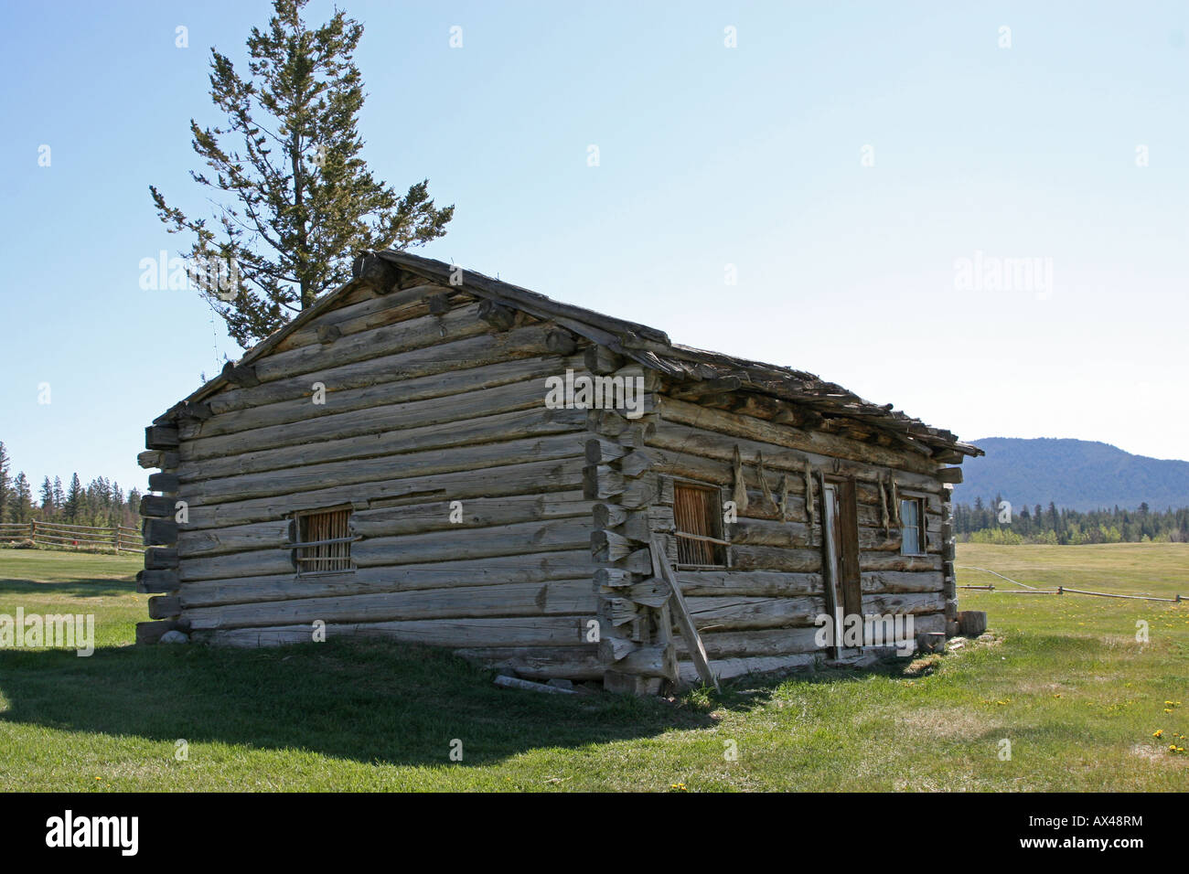 Log cabin with fields and blue sky in the background Stock Photo - Alamy
