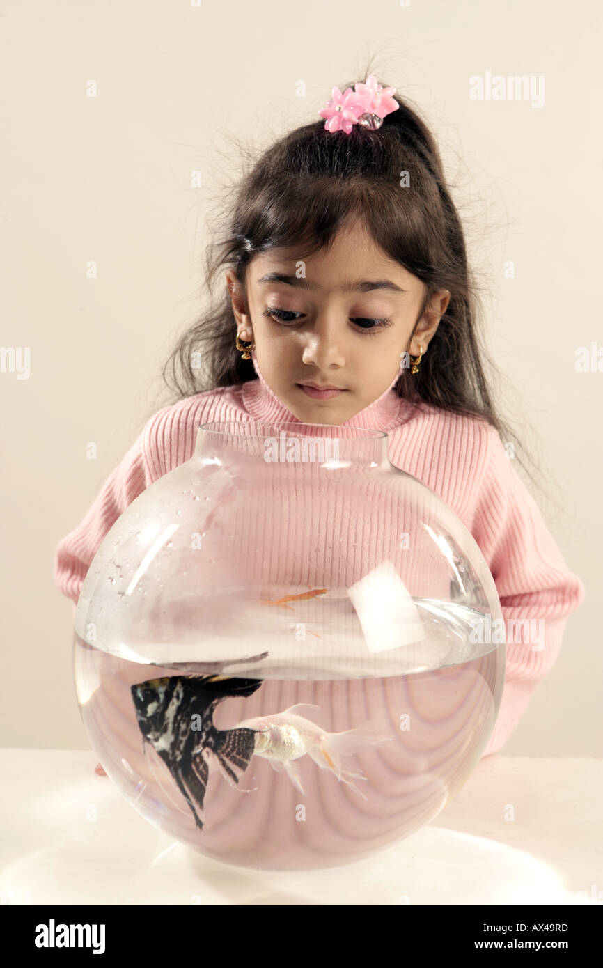 Girl watching fish in a fishbowl Stock Photo - Alamy
