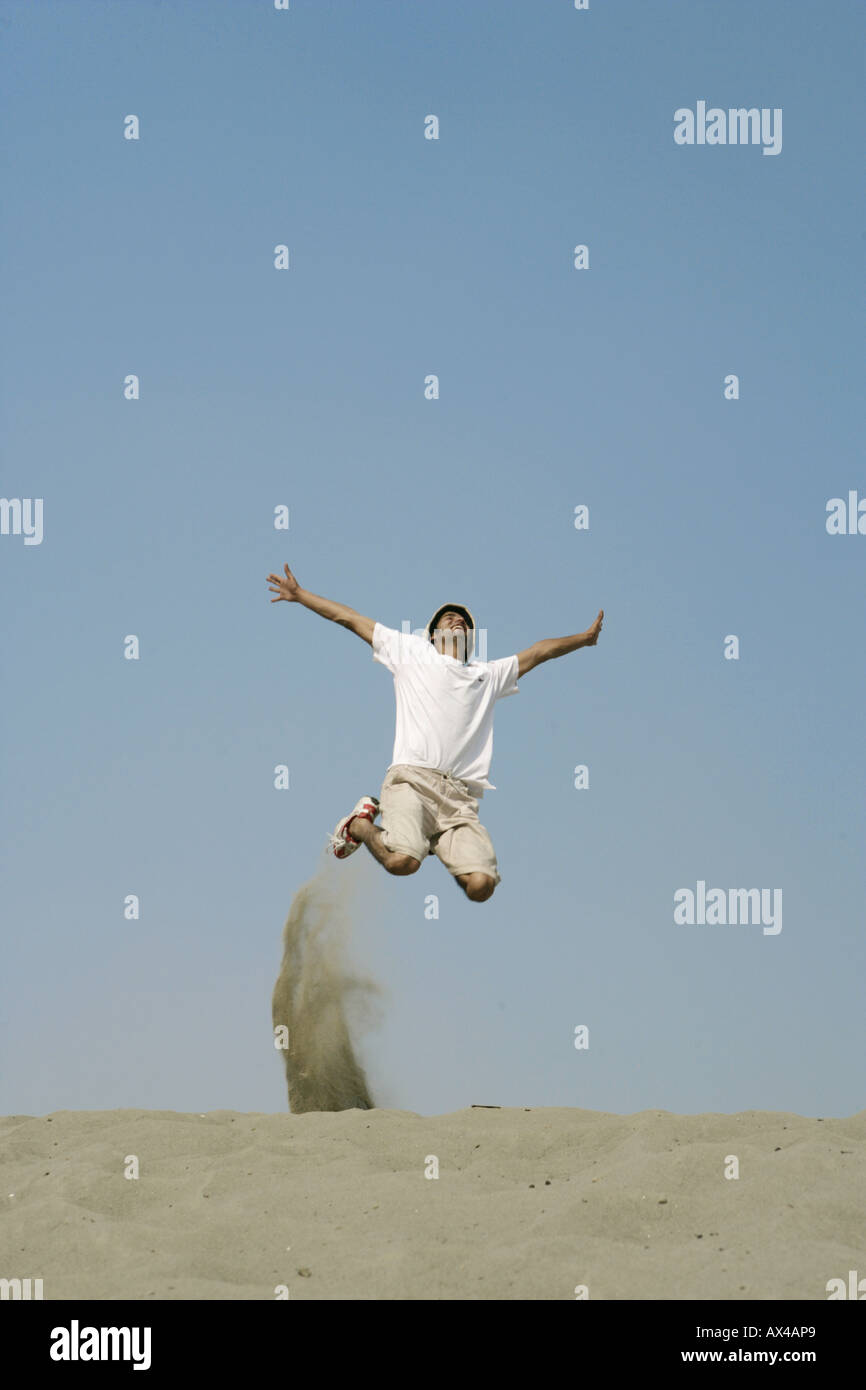 Low angle view of a man jumping in a desert Stock Photo - Alamy