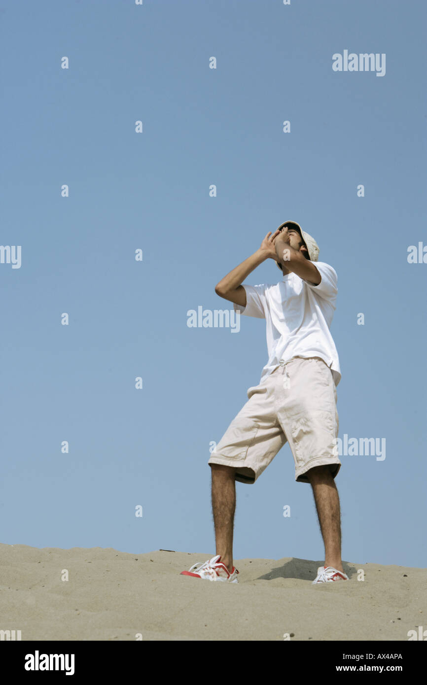 Low angle view of a man shouting in a desert Stock Photo - Alamy