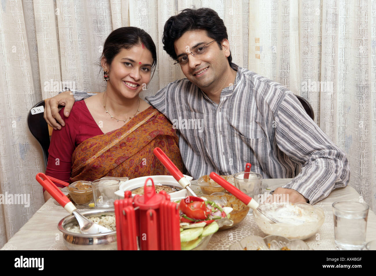 Portrait of a couple eating at dining table and smiling Stock Photo - Alamy