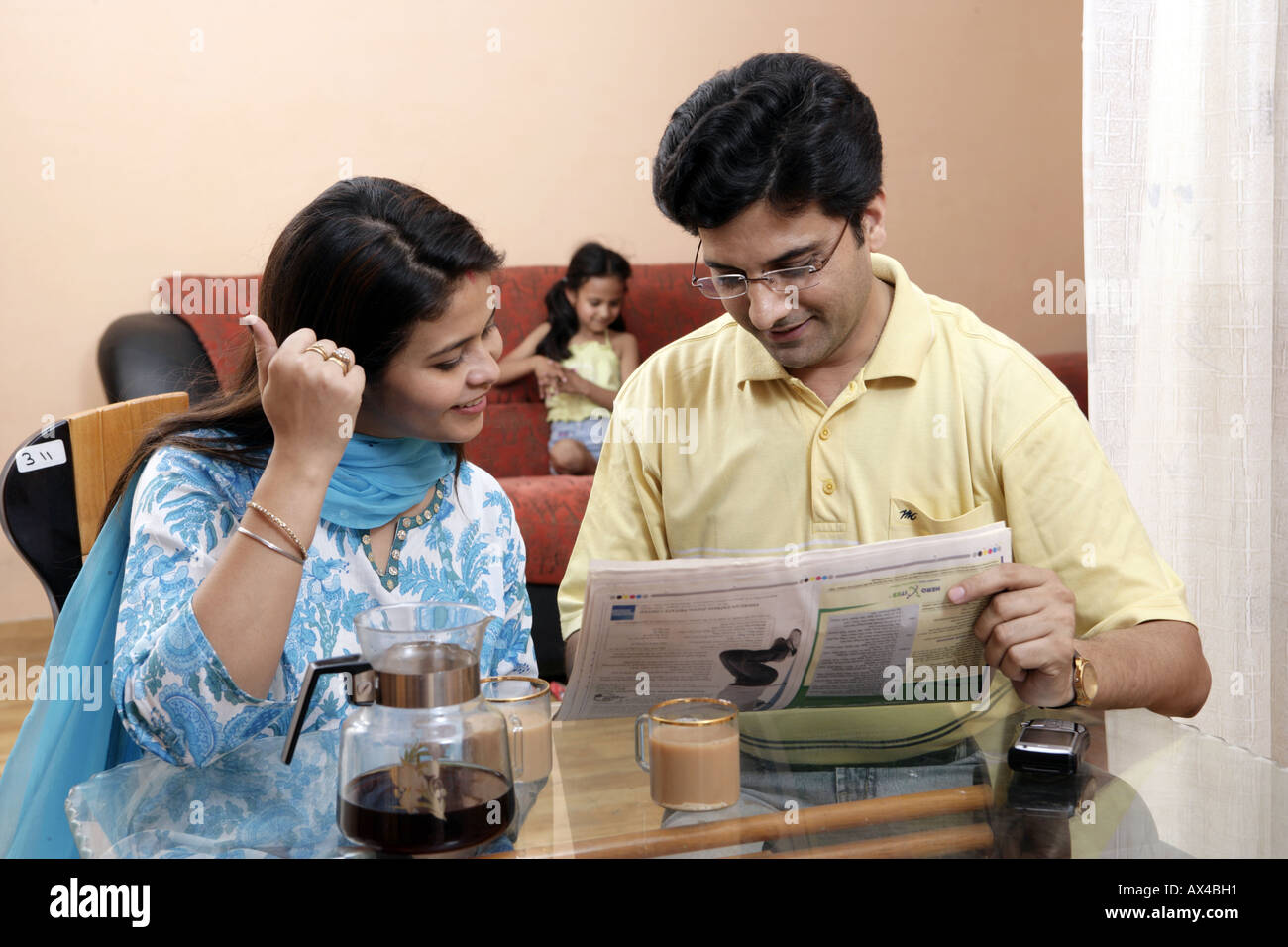 Couple reading newspaper at dining table Stock Photo - Alamy