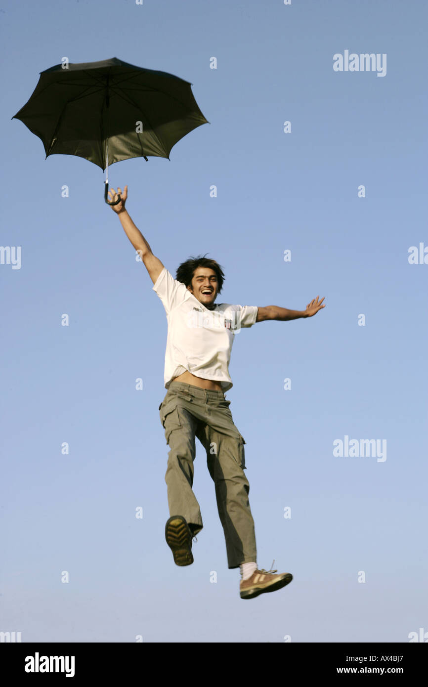 Low angle view of a young man jumping and laughing Stock Photo - Alamy