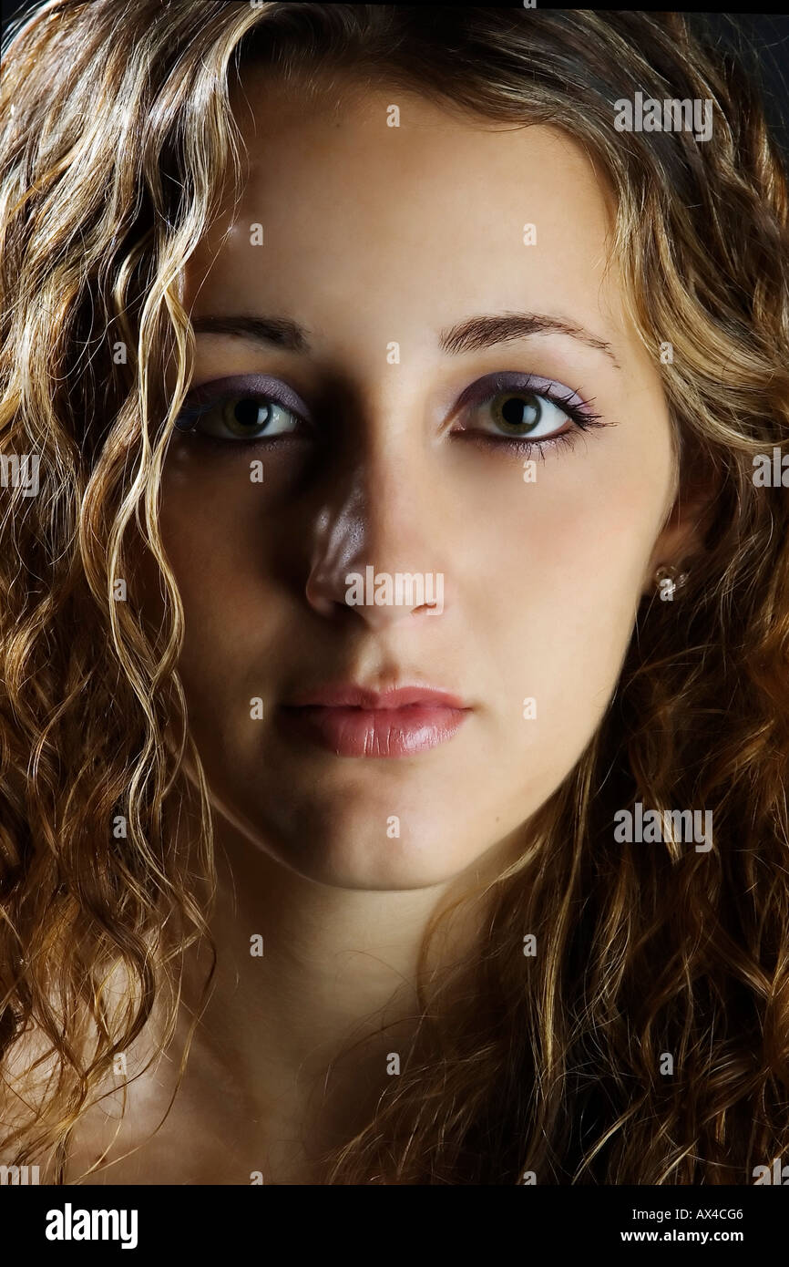 An attractive model lit by a sidelight giving many shadows and ...