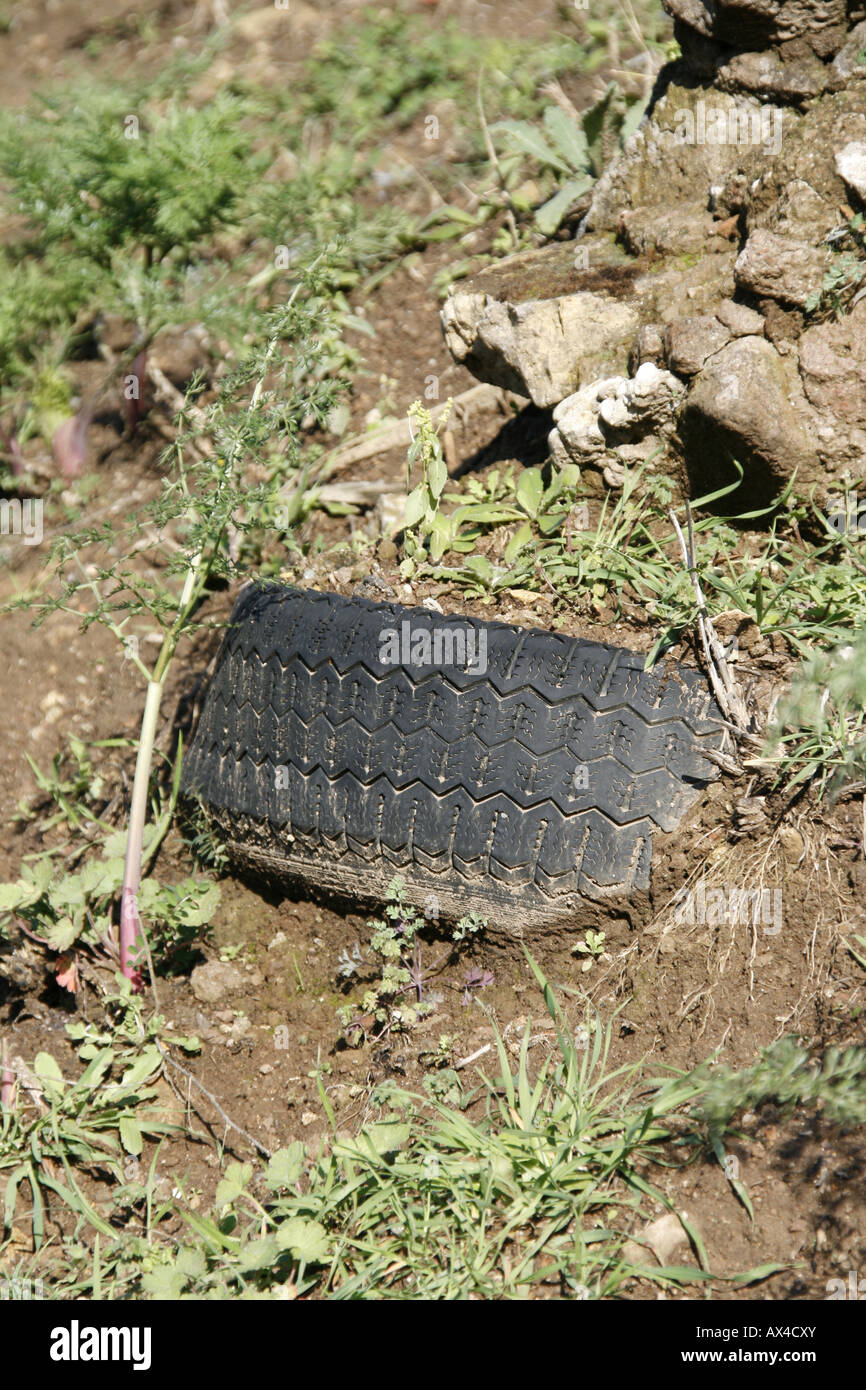 car tyre dumped in countryside Stock Photo - Alamy