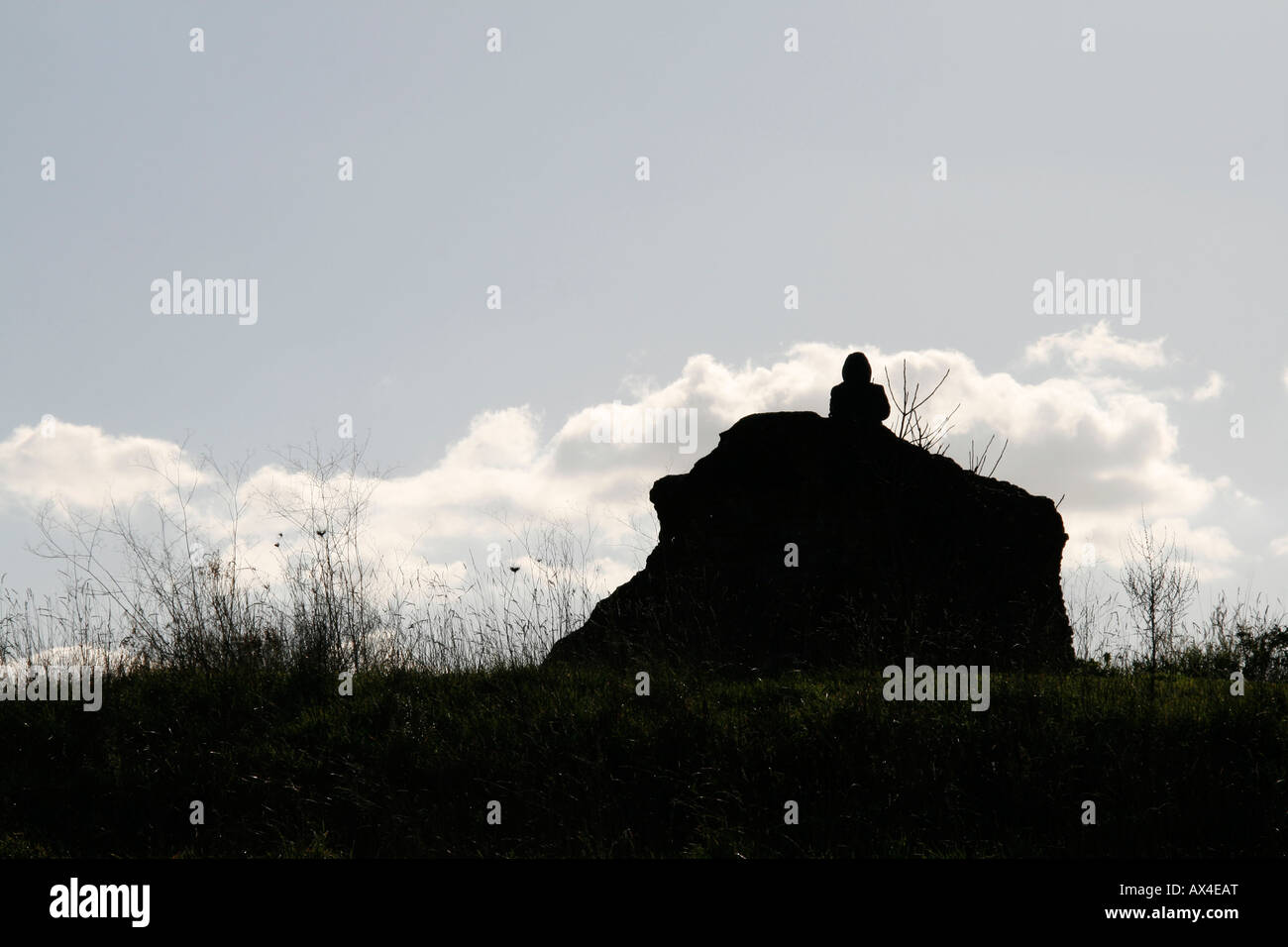 person sitting on rock in countryside Stock Photo - Alamy