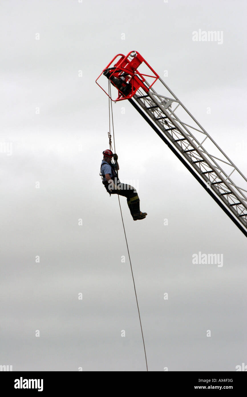 A firefighter doing an aerial rescue descent from an extending ladder ...