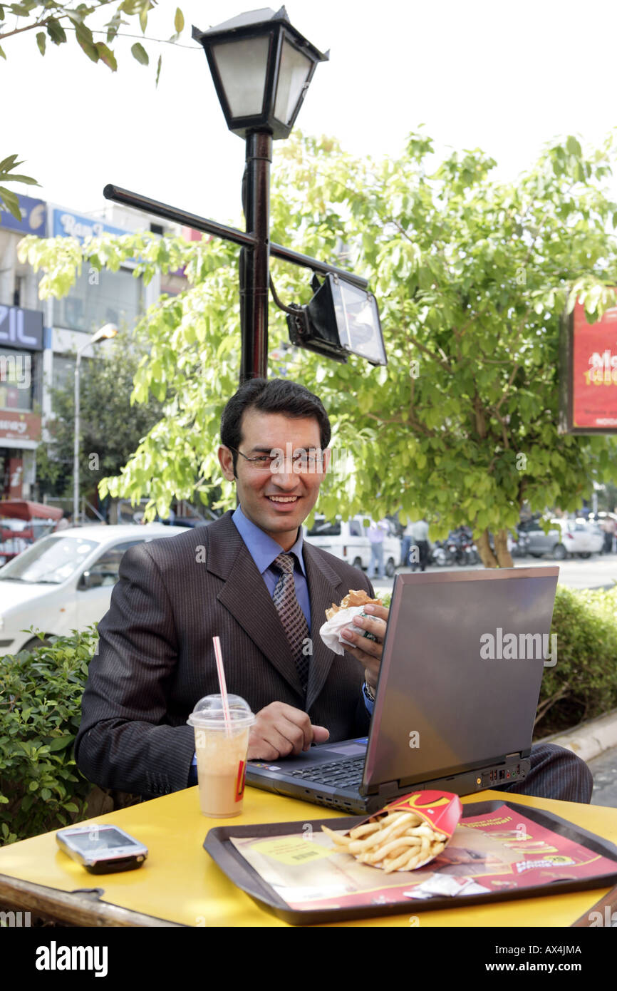 Portrait of a business man eating burger in a cafeteria Stock Photo - Alamy