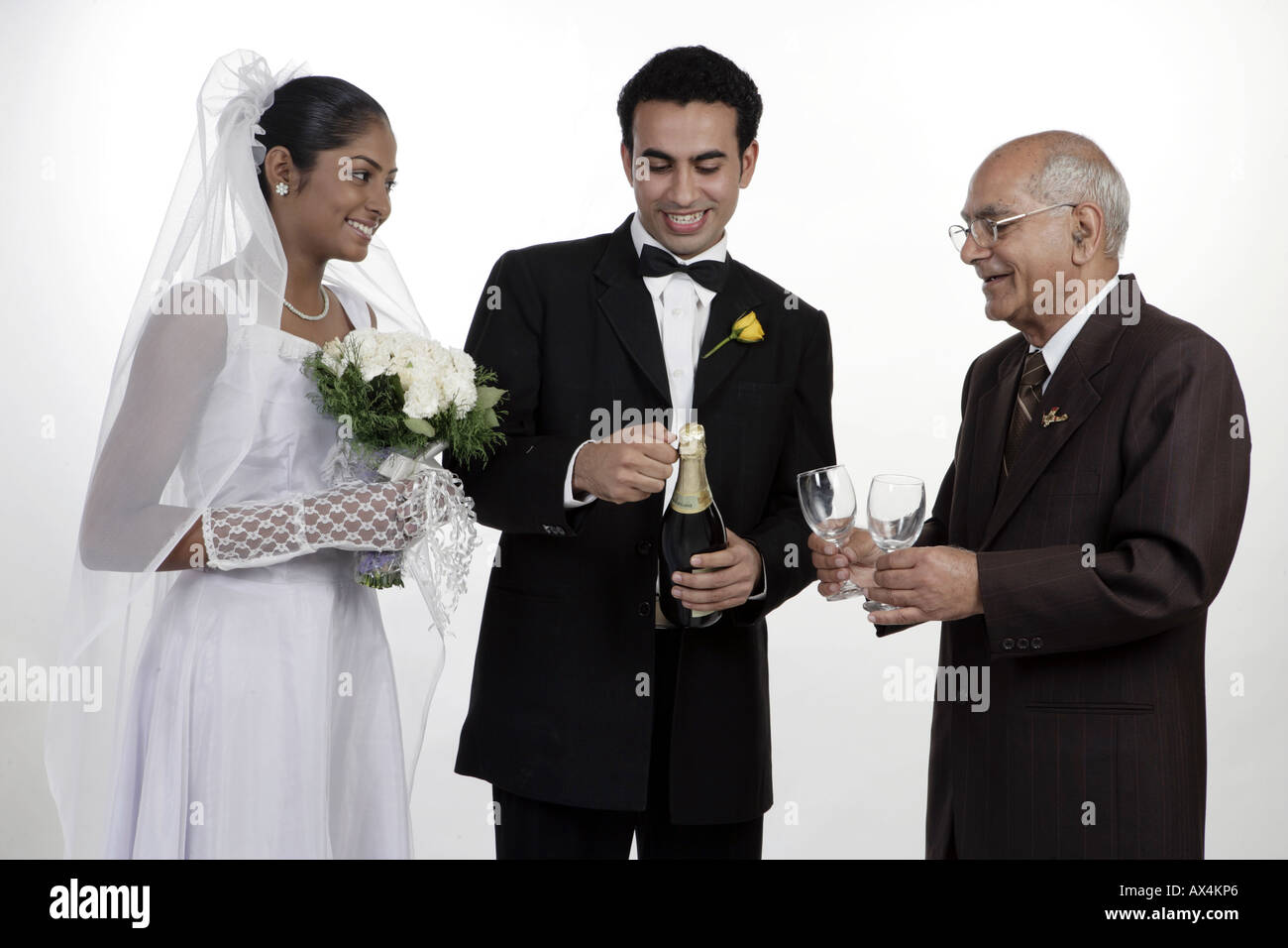 Bride and groom celebrating their marriage with their father Stock ...