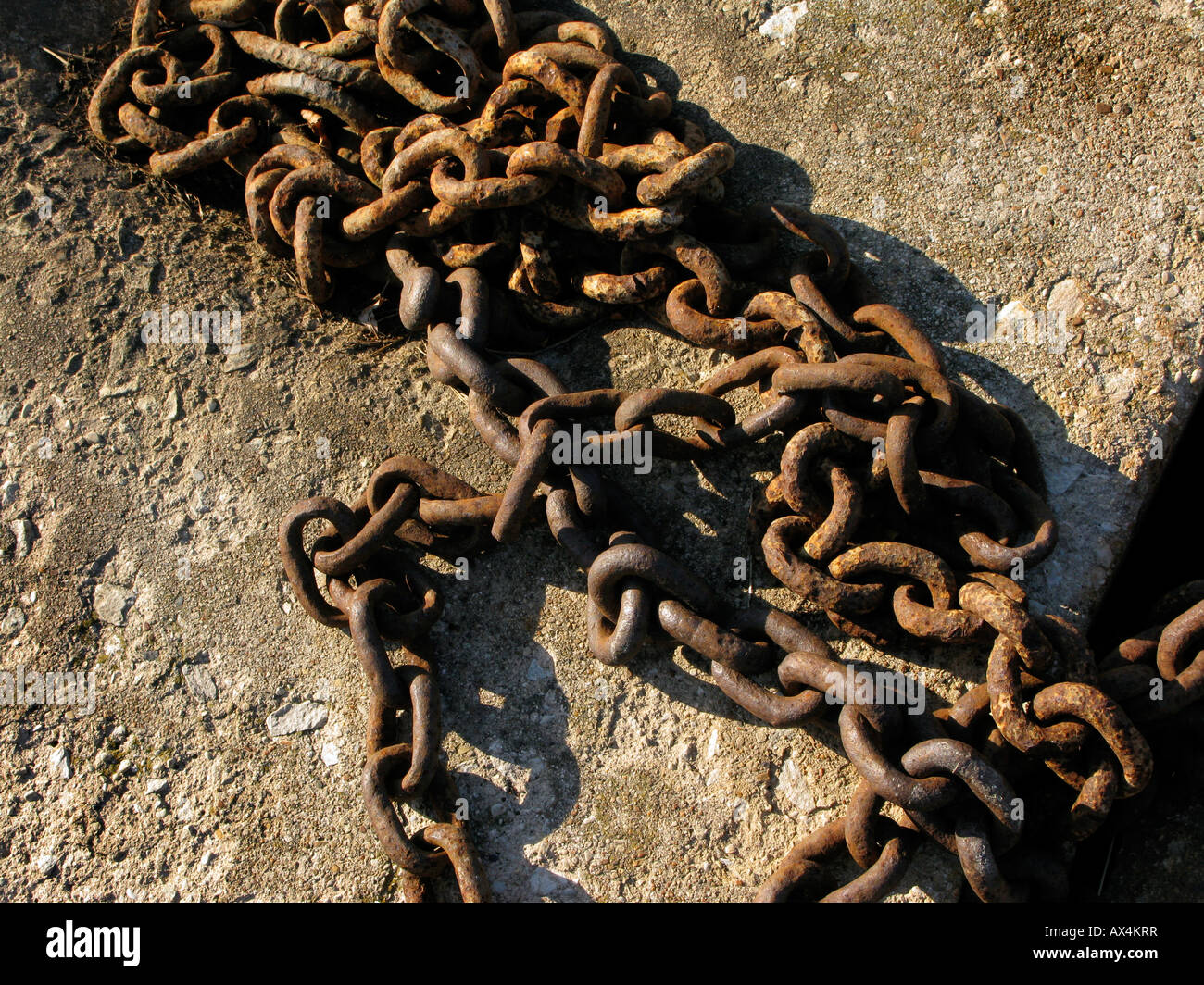 Pile of rusty chain on stone Stock Photo - Alamy