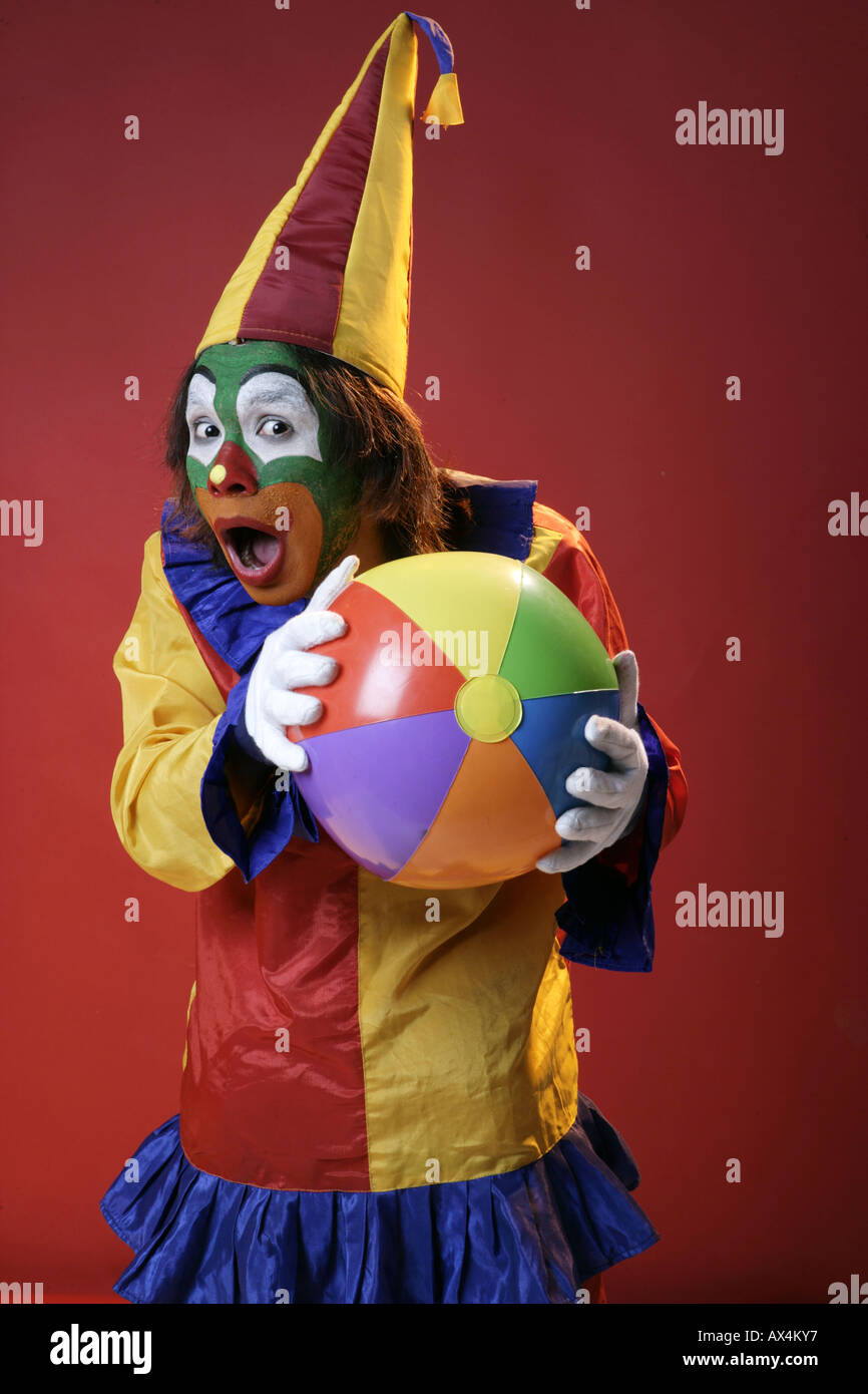 Portrait of a joker holding a ball and looking shocked Stock Photo - Alamy
