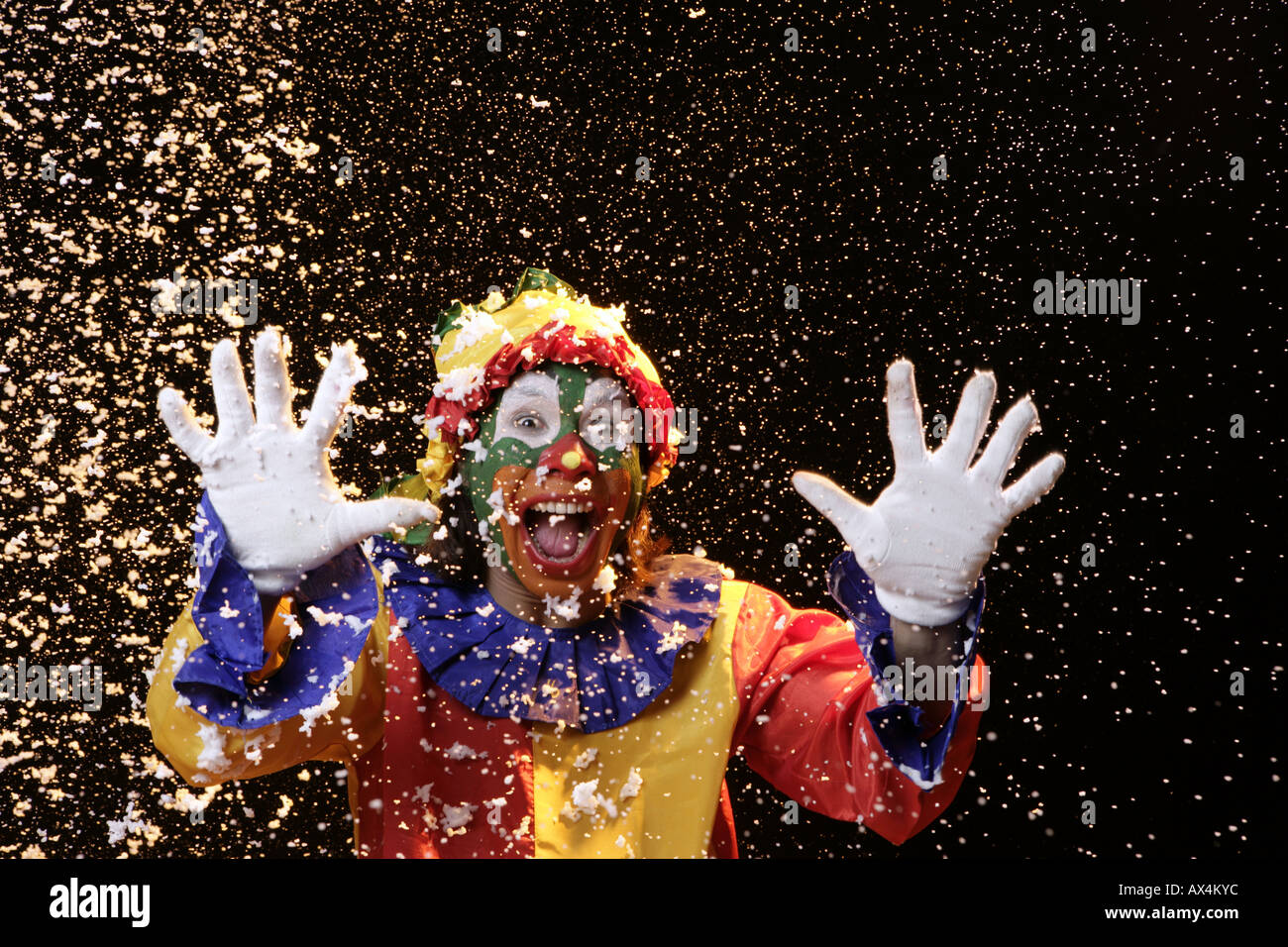 Portrait of a joker performing on stage with confetti falling on him ...