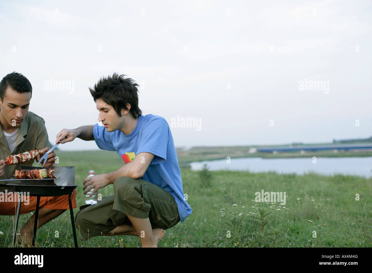 Two young men grilling Stock Photo - Alamy