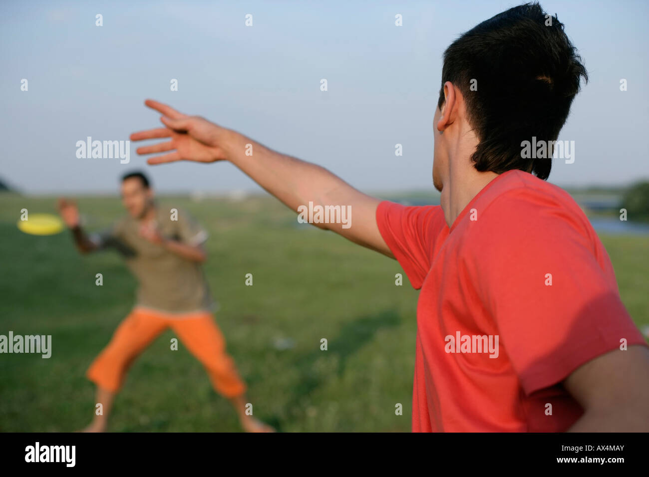 Two young men playing with a frisbee Stock Photo - Alamy
