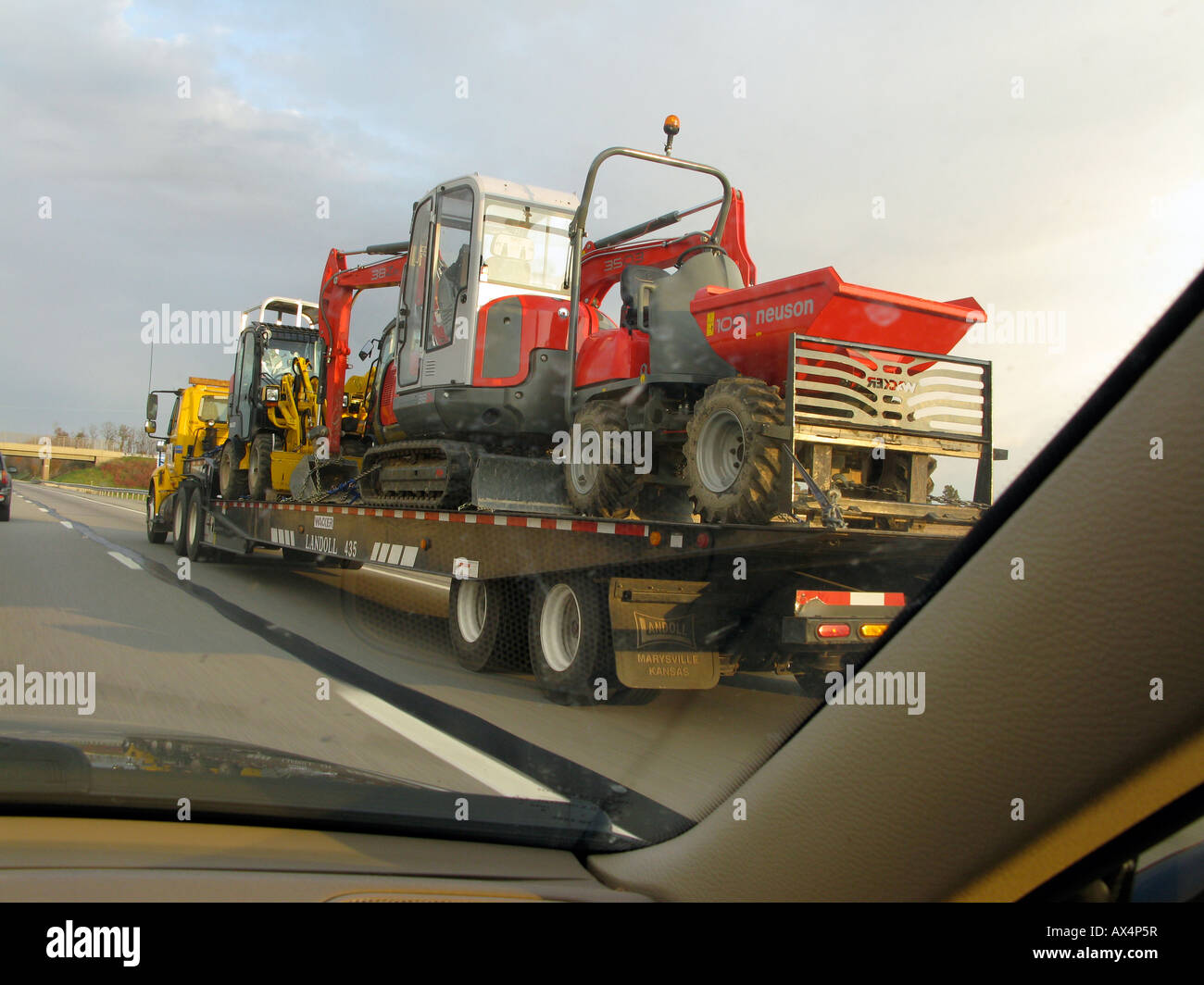 Flatbed truck transporting earth moving machines Stock Photo - Alamy