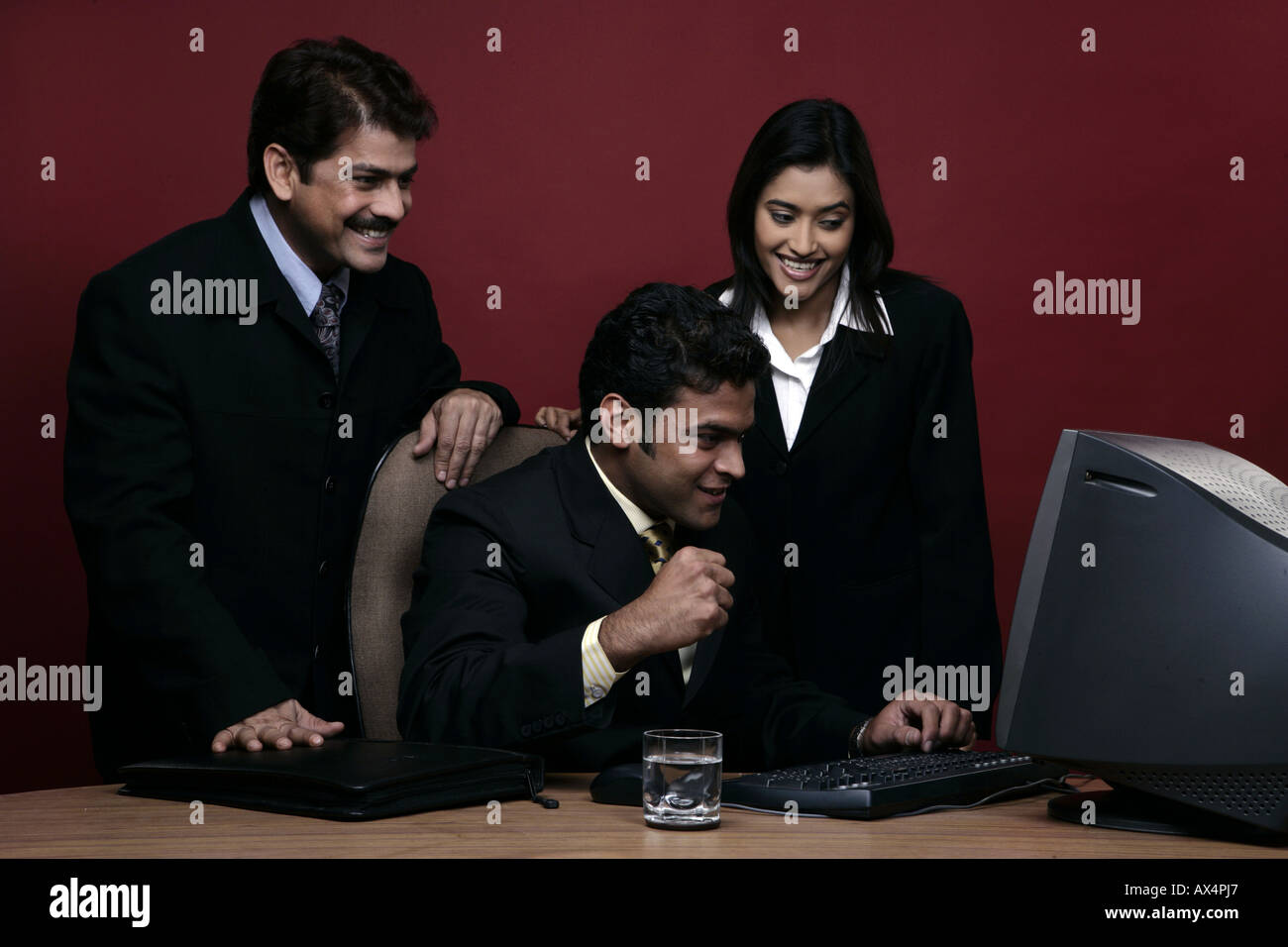 Three business people working on a computer Stock Photo - Alamy