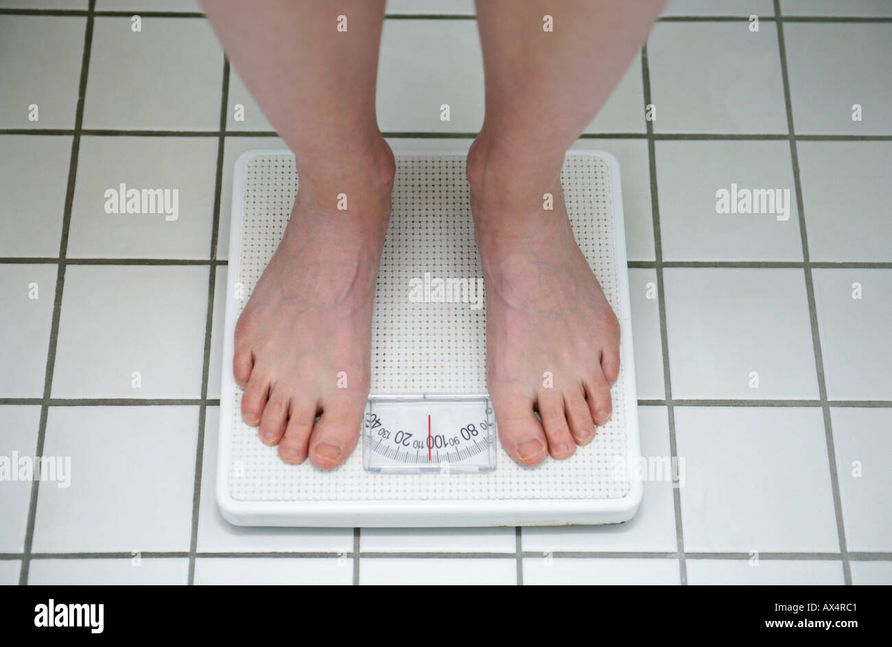 Woman standing on scale Stock Photo - Alamy
