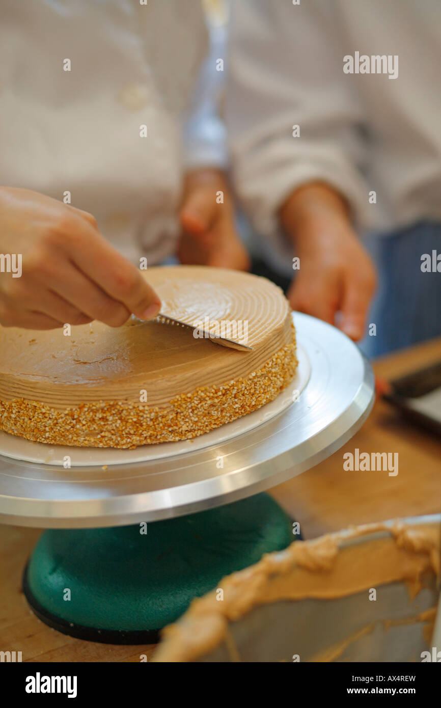 Pastry chef spreading icing over coffee cream cake Stock Photo - Alamy