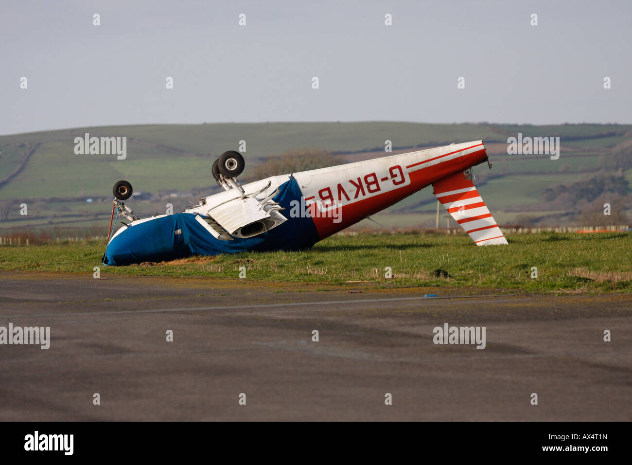 Small Airplane crash upside down on airfield, blown by gust of wind ...