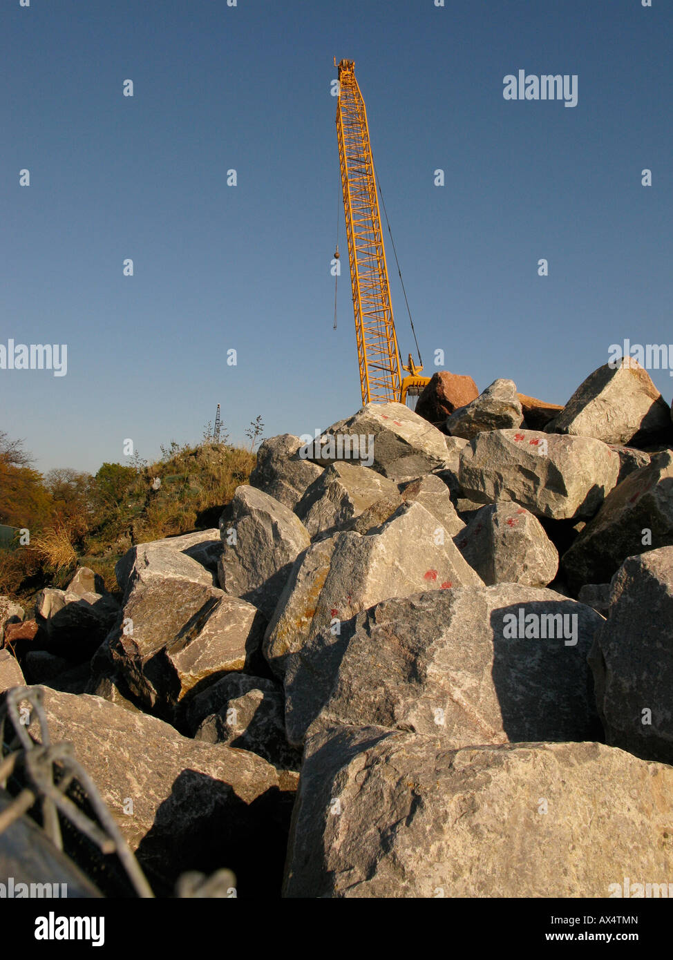 Construction site with rocks and crane Stock Photo - Alamy