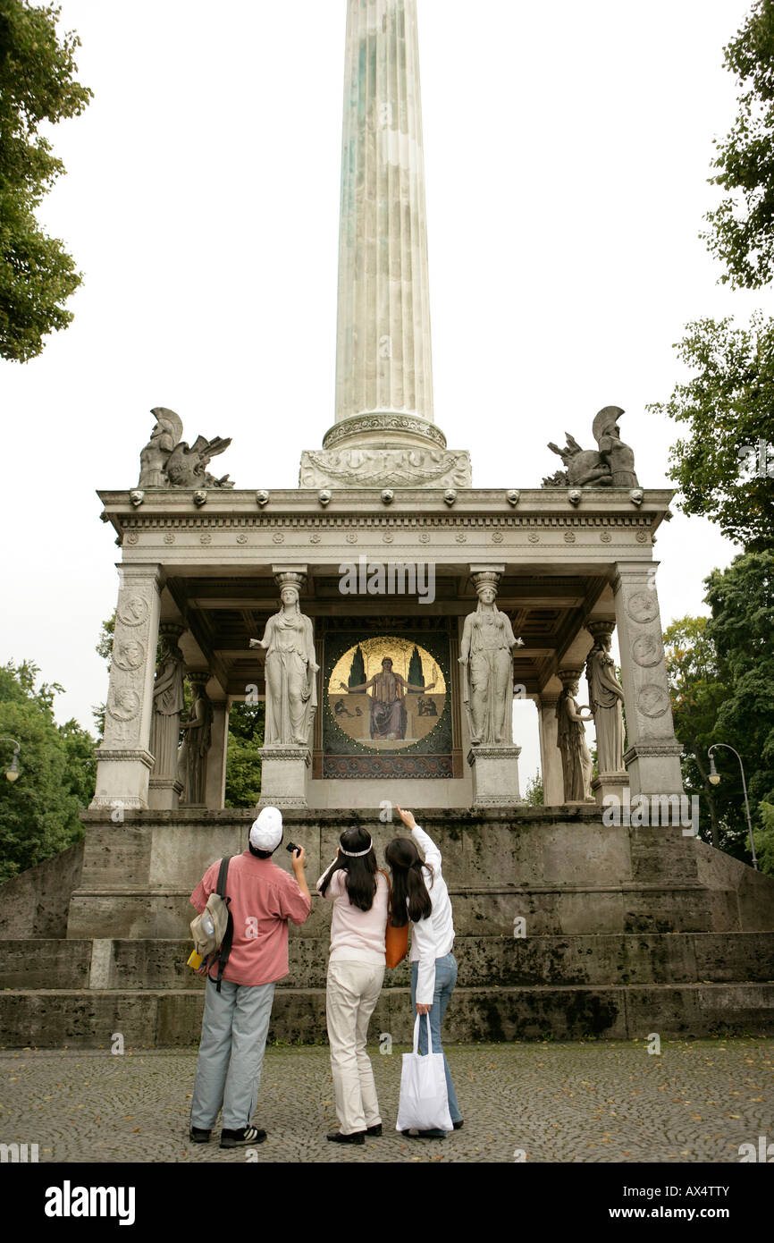 Three people looking at a monument Stock Photo - Alamy