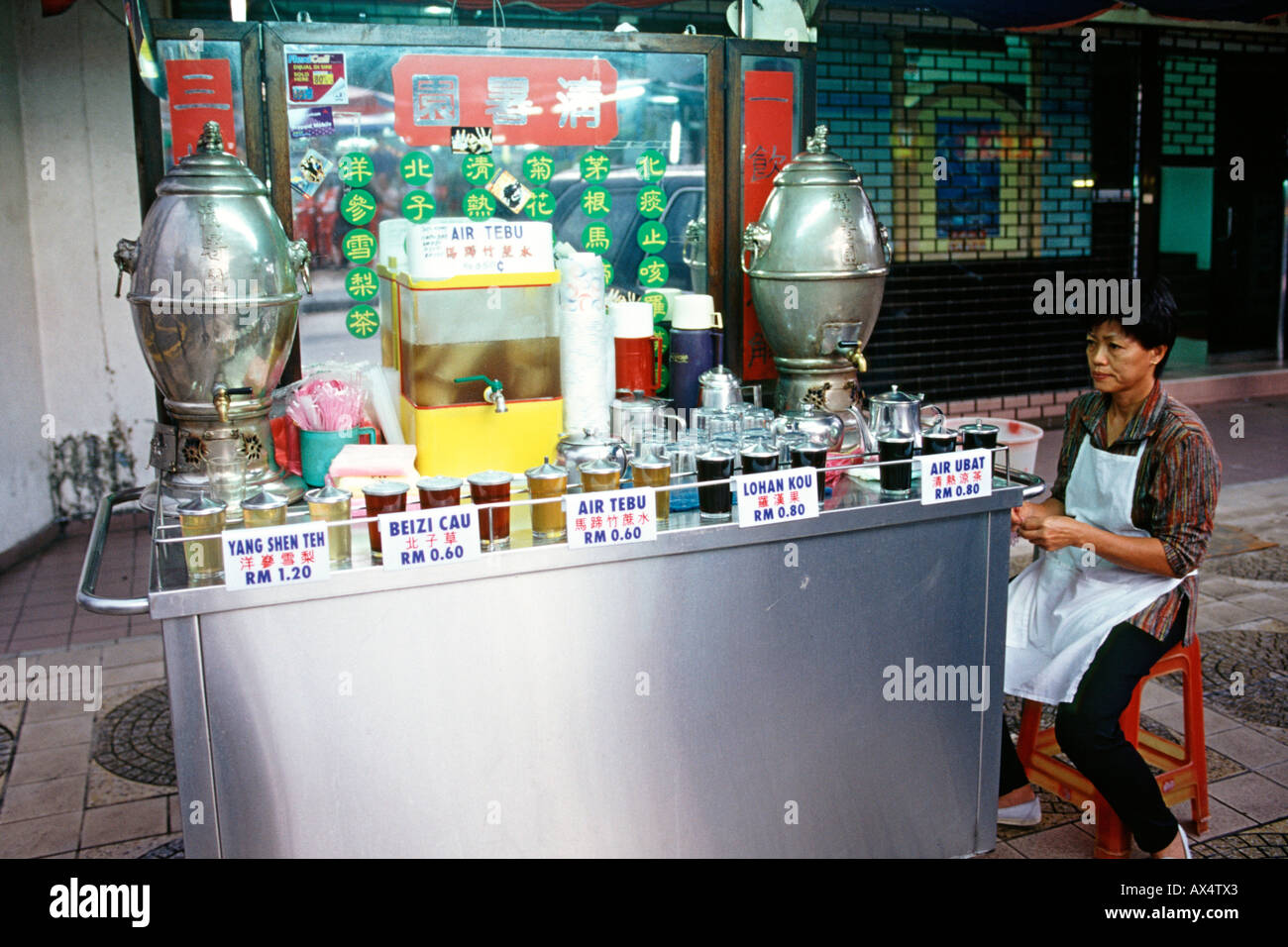 A woman and her refreshment vending stall on a Kuala Lumpur street in ...