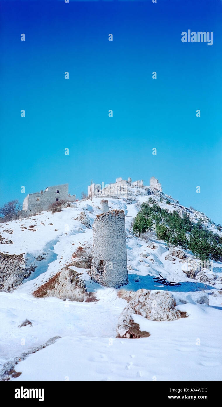 The ruins of ancient mountain top fort is surrounded by snow under a ...