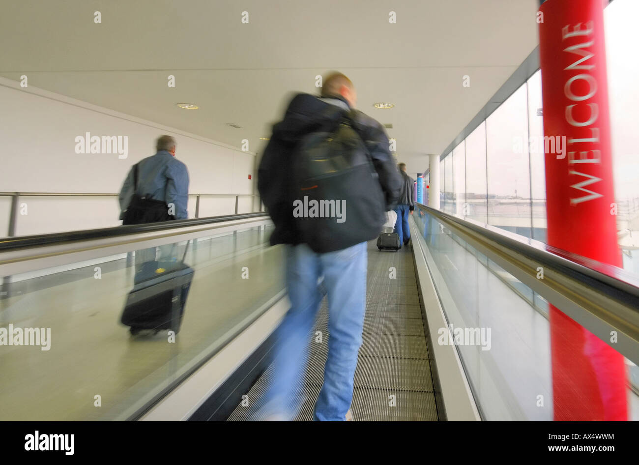 Travellers pass near a column with "Welcome" greeting written on it ...