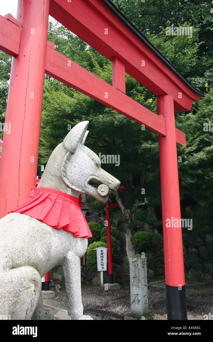 Red torii gate and fox statue at shinto shrine in Japan Stock Photo - Alamy
