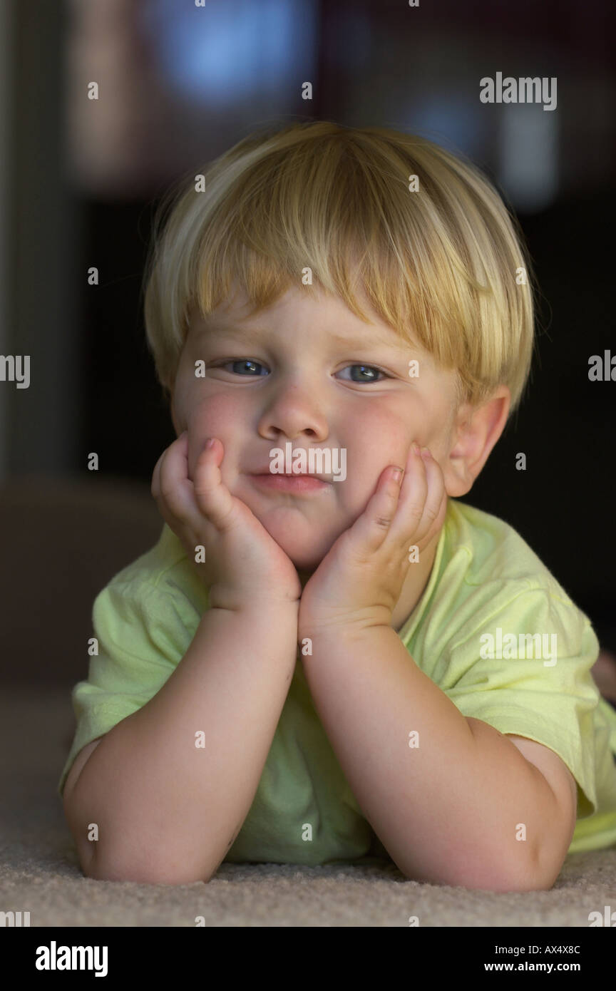 toddler lying down with hands on face Stock Photo - Alamy
