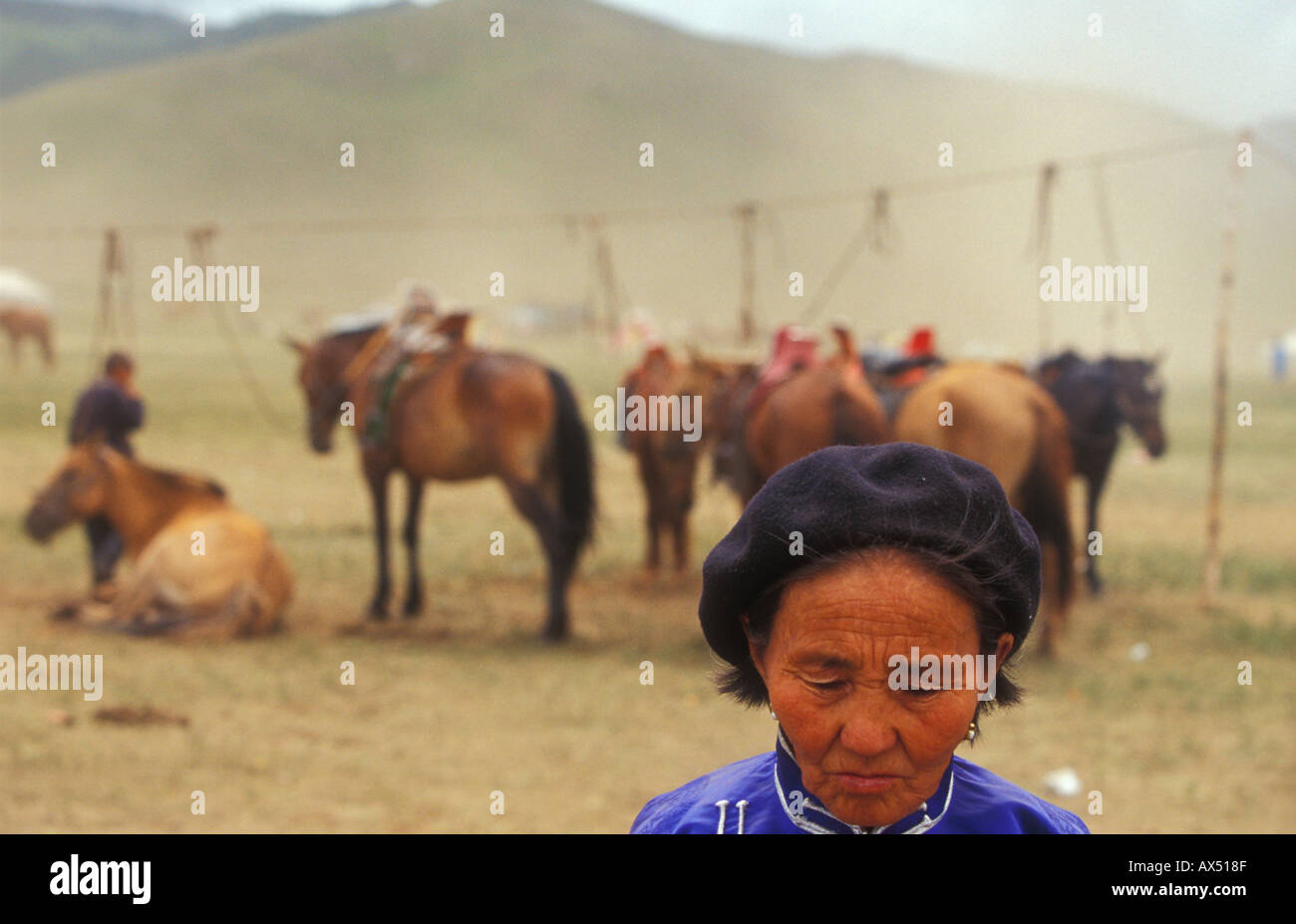 A Mongolian woman stands near tied up horses outside Ulan Bator ...