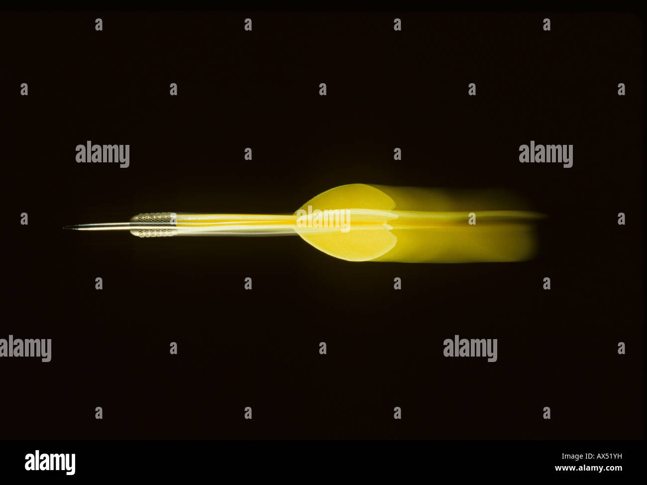Yellow dart flies through air Stock Photo - Alamy