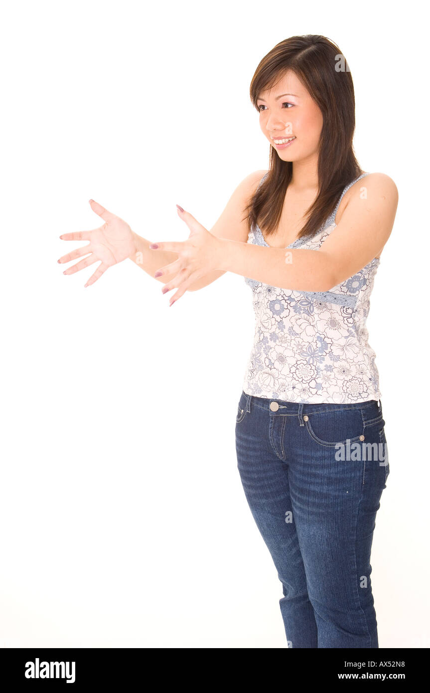 A young asian woman in casual clothes has her hands outstretched ready ...