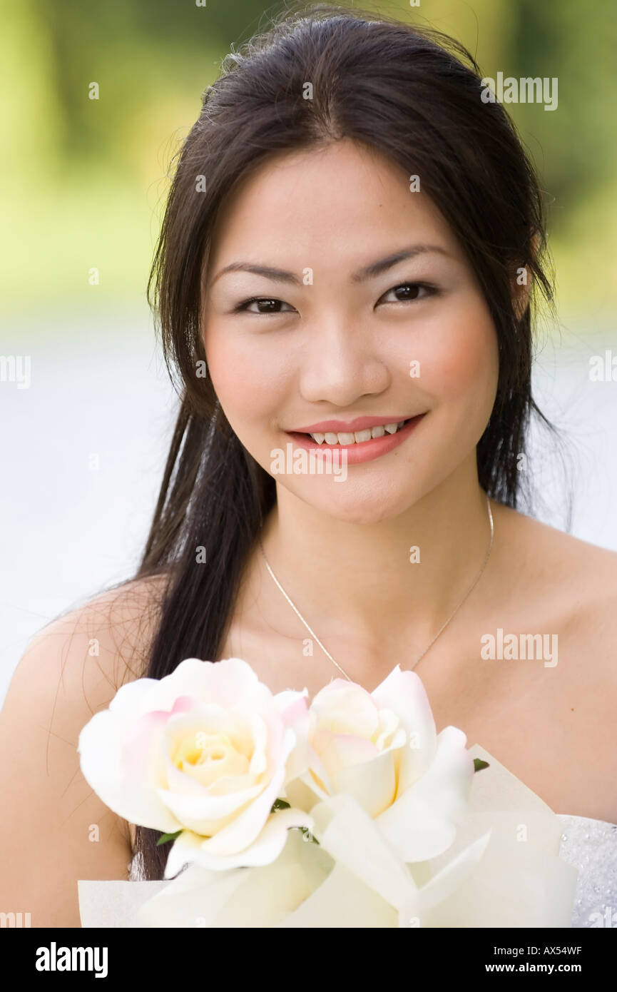 A stunning asian bride in her wedding dress poses by a lake Stock Photo ...