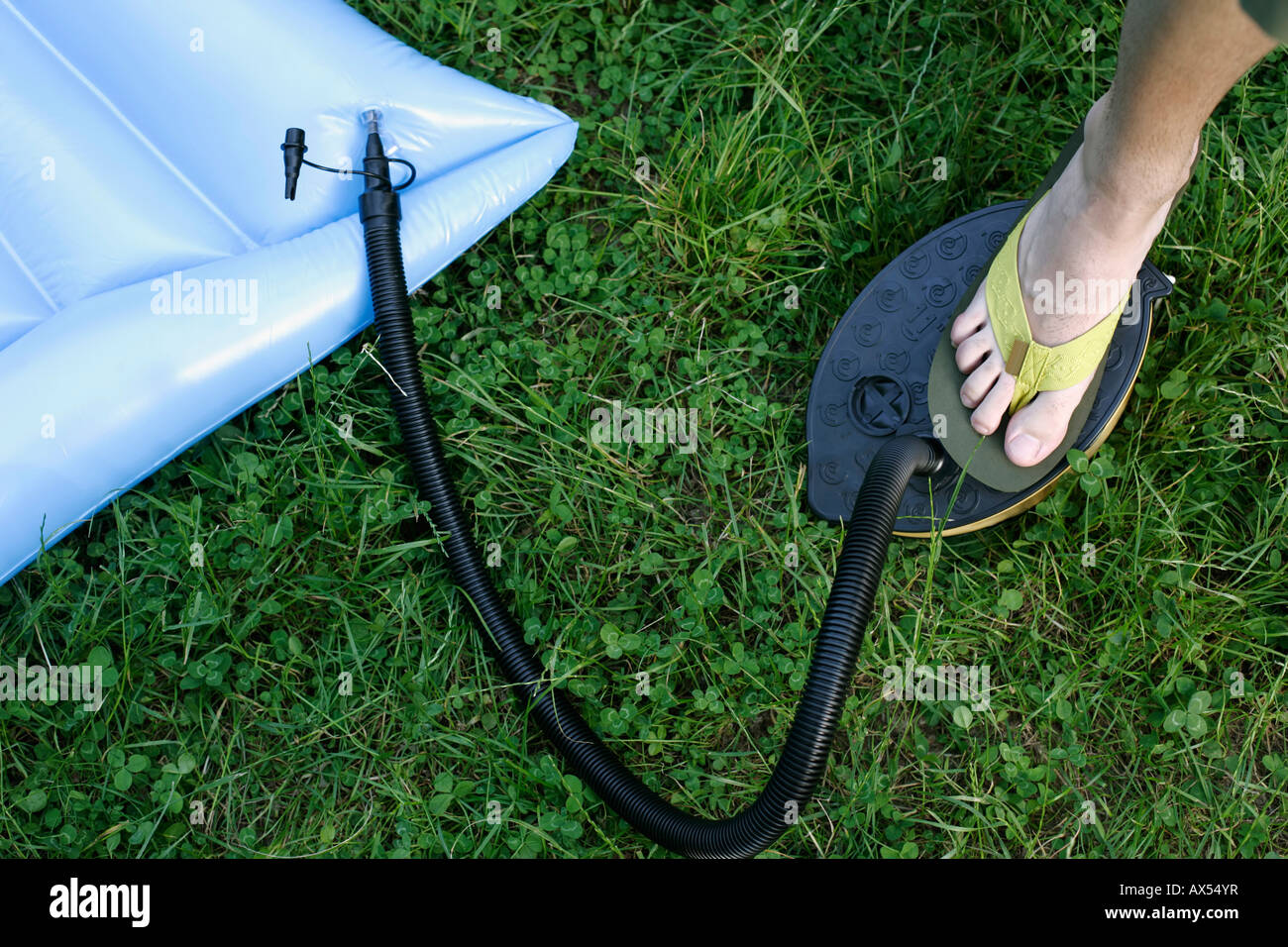 Man pumping up a blue airbed Stock Photo - Alamy