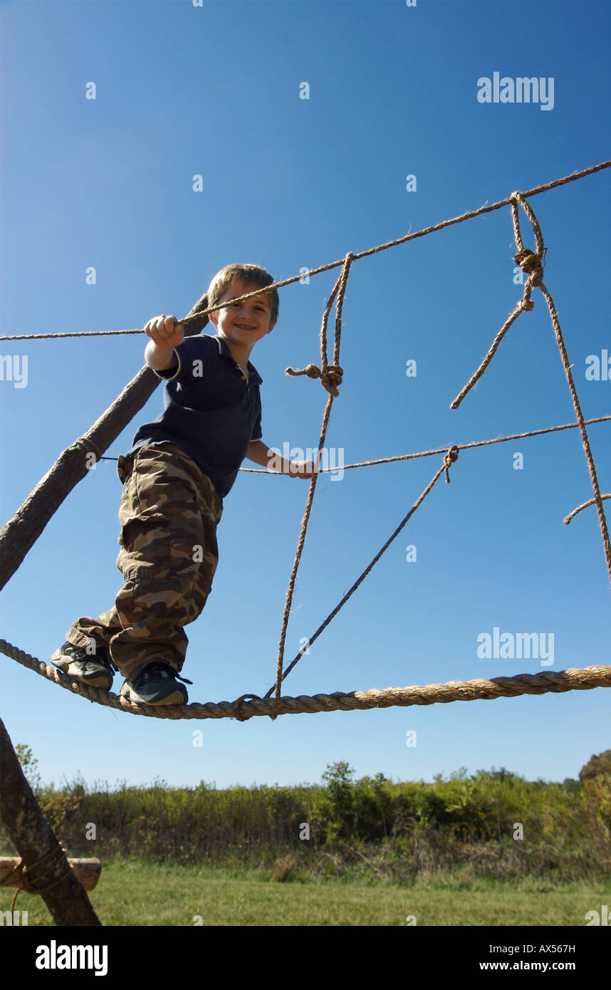 Four year old boy crossing a rope foot bridge at a Cub Scouts of ...
