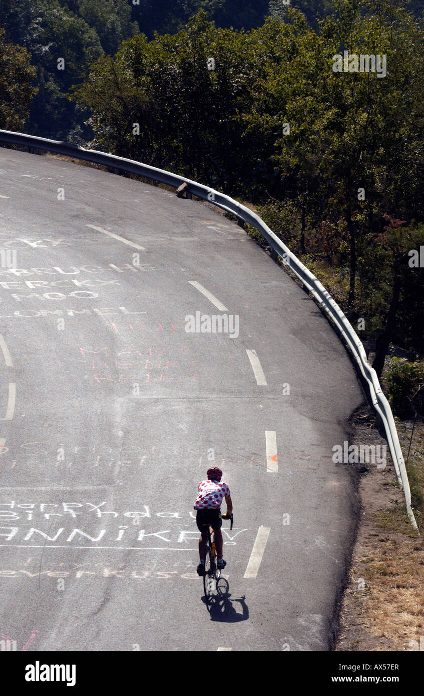 a lone rider climbing the famous alp d'huez mountain in the french alps ...