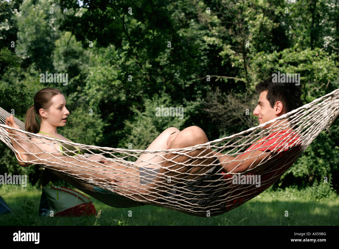 Young couple lying in a hammock face to face Stock Photo - Alamy