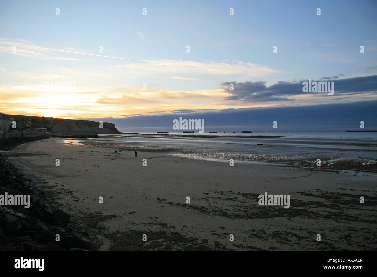 View looking along Arromanches beach at sunset, Normandy Stock Photo ...