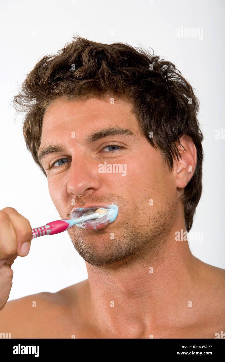 Young man brushing teeth, portrait Stock Photo - Alamy