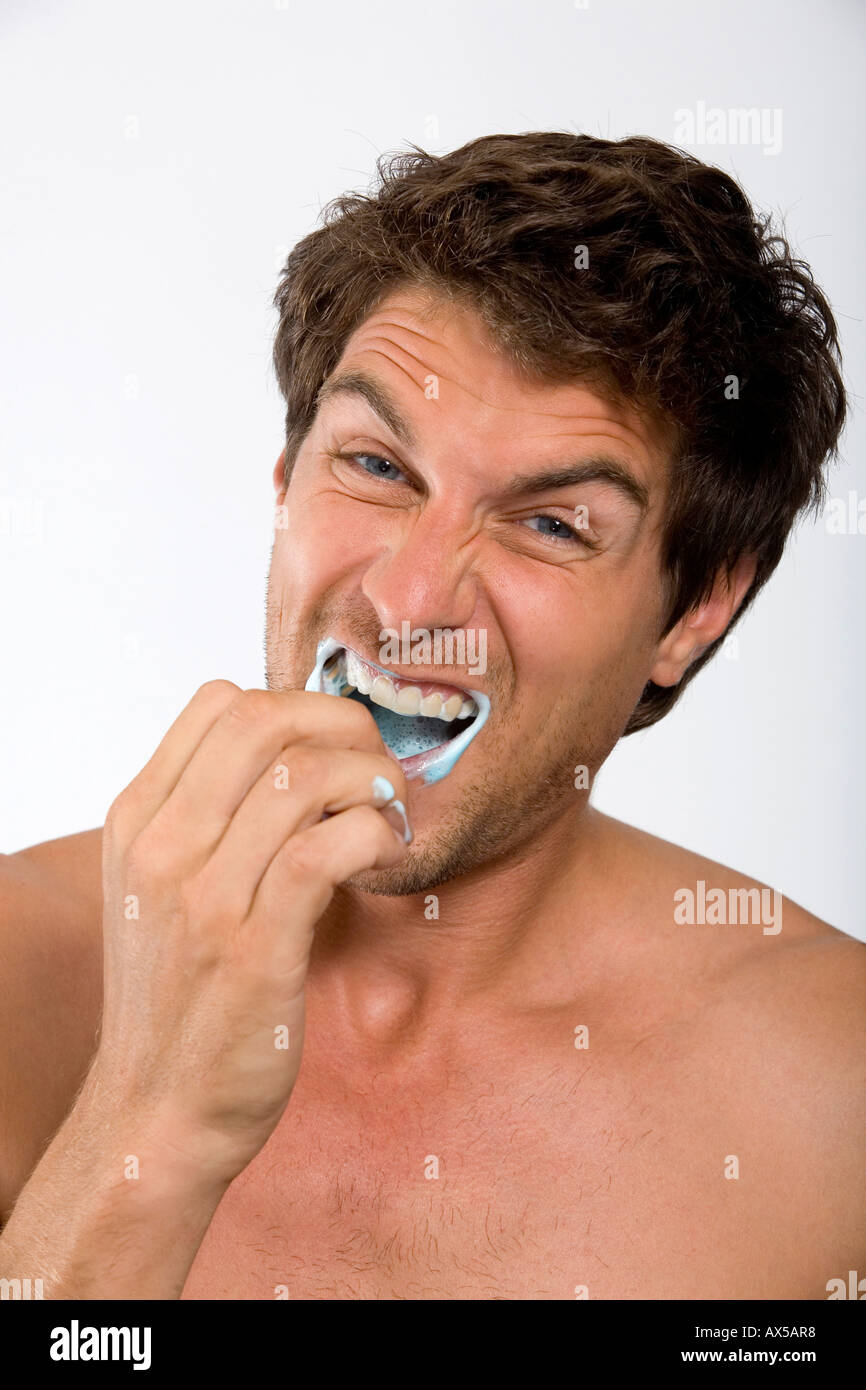 Young man with tooth paste in mouth Stock Photo - Alamy