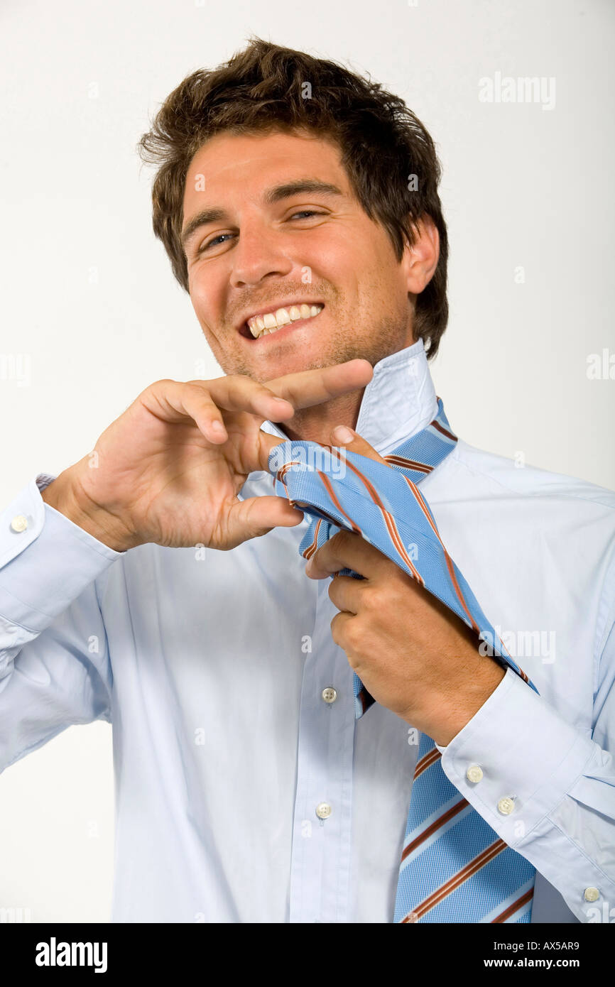 Young man binding tie, portrait Stock Photo - Alamy