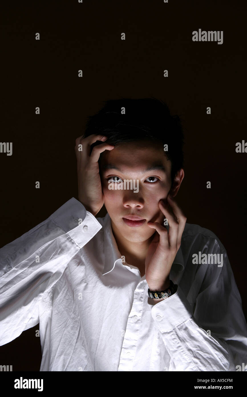 Young man holding hands to his face Stock Photo - Alamy